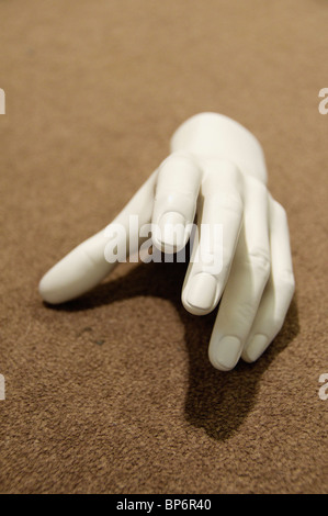 Close up of a mannequin hand reaching upward against a black background ...