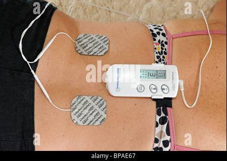Woman female using a Lloyds Pharmacy TENS Digital Pain Reliever to help ...