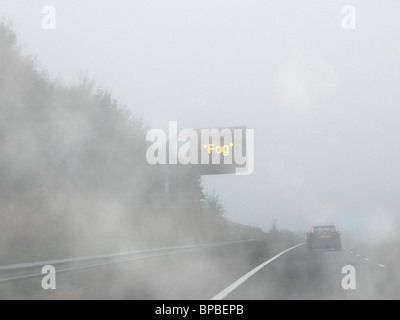 Variable message sign warning drivers of fog on a foggy UK motorway ...