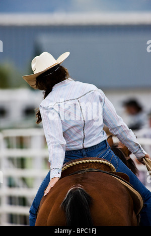 Cowgirl on horseback competes in the tie-down roping event, Chaffee ...