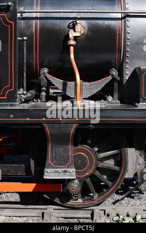 Close-up detail of railway steam engine metal wheel and of piston ...