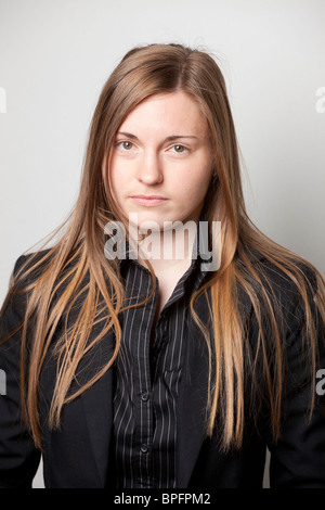 A focused woman with long straight black hair, wearing glasses with ...
