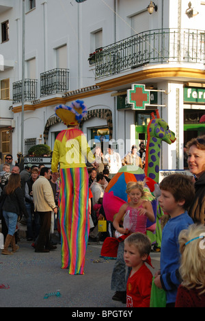 Three people on stilts in carnival costumes celebrate the victory of ...