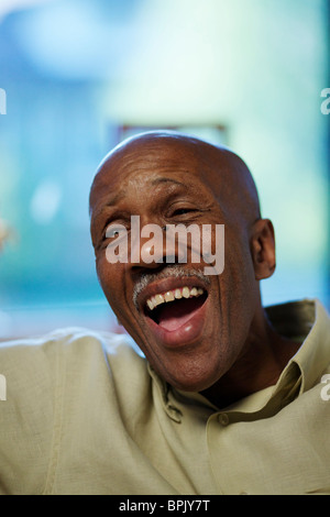 Fun black African man laughing and smiling standing outside Stock Photo ...