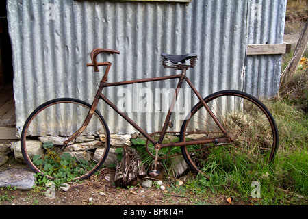 Rusty bicycle leaning against a galvanised iron shed Stock Photo - Alamy