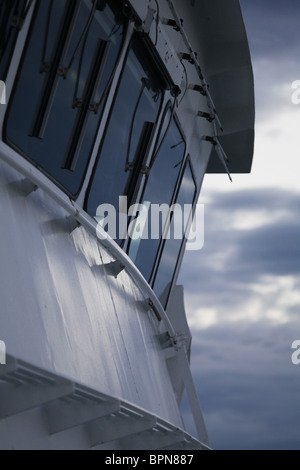 The windows of the bridge of a ferry boat ship under dark skies in the ...