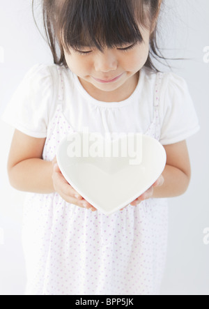 Girl holding a heart-shaped plate Stock Photo - Alamy