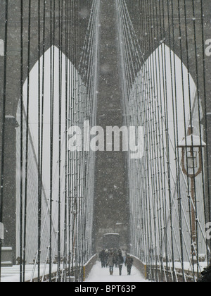 Brooklyn Bridge at snow storm, a view to Manhattan buildings in fog ...