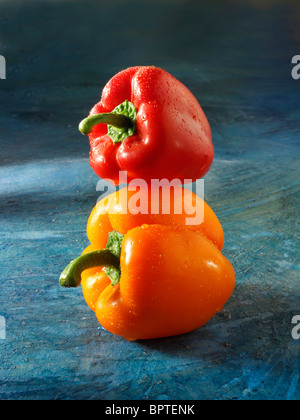 one fresh red bell pepper on a wooden cutting board on gray background ...
