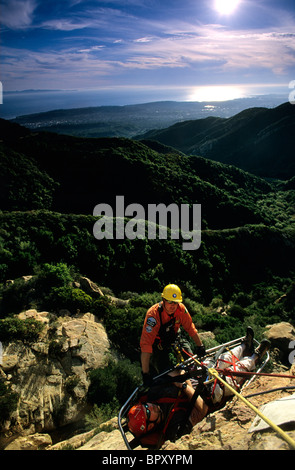 Search and Rescue climber tending litter, wide shot lowering from South ...