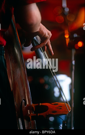 Fingers plucking acoustic bass strings Stock Photo - Alamy