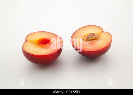 Red Plum cut in half isolated on white background Clipping Path. Full ...