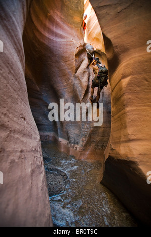 A woman descending desert slot canyon, Utah Stock Photo - Alamy