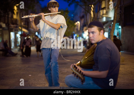 Boys dressed in traditional Israeli and Jewish clothes play the flute ...
