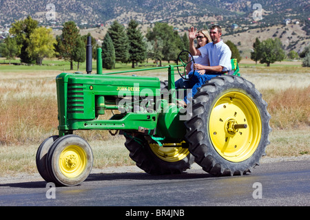 Newlywed married couple riding on antique tractor in their wedding ...