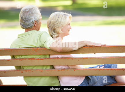 Senior couple sitting together at the park and smiling at camera Stock ...