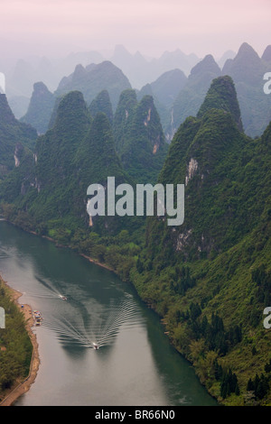 Karst limestone mountains along river with lush vegetation in Ninh Binh ...