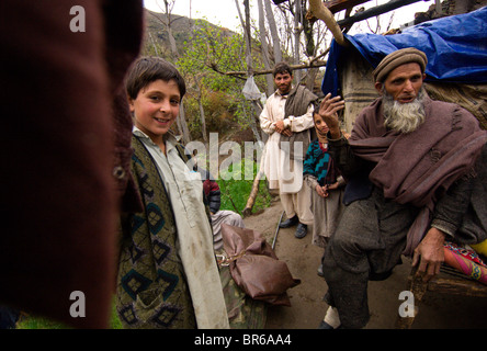 A Pashtun family who have just arrived back to their ruined mountain ...