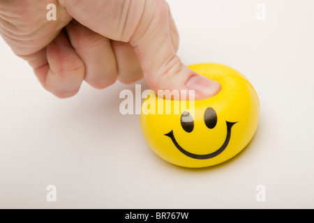 Yellow Happy Face Being Squeezed By A Thumb; Edmonton, Alberta, Canada ...