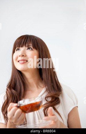 View of a woman holding a cup and saucer and smiling Stock Photo - Alamy