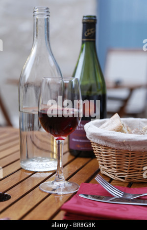 Bottle of red wine with wineglass. Water splash and droplet on the ...