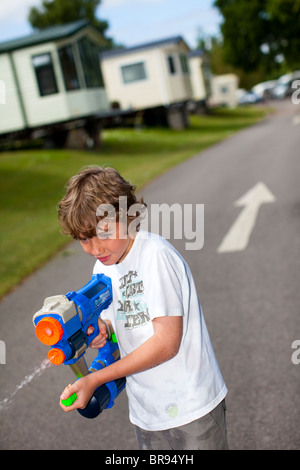 Boy shooting water pistol Stock Photo - Alamy