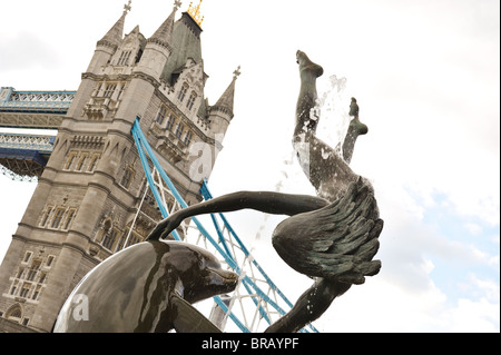 Tower Bridge and Dolphin and a boy statue at dusk, North Bank, London ...