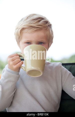 Young boy drinking from a coffee mug Stock Photo - Alamy