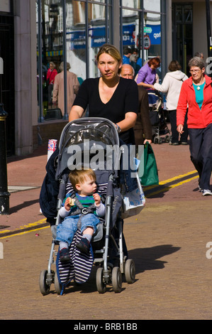 A woman pushing a pushchair and toddler in front of the Breakfast Club ...