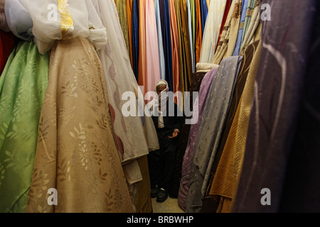 A shopkeeper in a textile shop in Qaysari bazaar in the city of Erbil ...