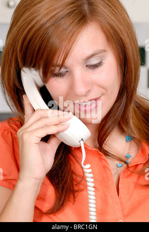 Young redhead woman talking on the phone with open hand doing stop sign ...