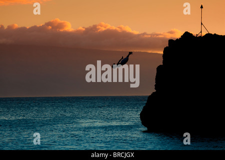 Cliff diver at the Sheraton Maui Resort and Spa before sunset torch ...