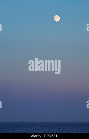 Square rigger pirate sailing ship in the mist at night with full moon ...