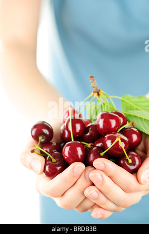 Two hands hold a fresh red tomato and a yellow bell pepper. The setting ...