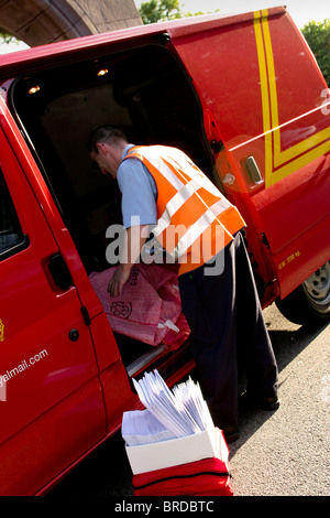 British postman wearing Hi Vis jacket and shorts delivering letters to ...