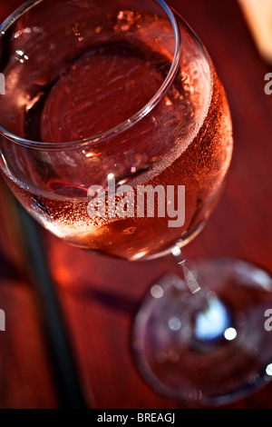 A glass of cold chilled rose wine served at a restaurant table. Water ...