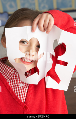 Female Primary School Pupil Cutting Out Paper Shapes In Craft Lesson ...