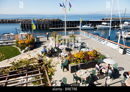 A waterfront cafe with patio overlooking a marina of boat slips and ...