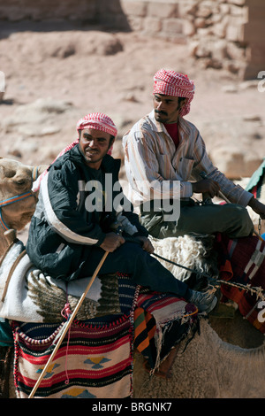 Bedouin riders on two camels standing in the shallow water of the Red ...