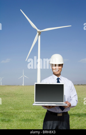 Engineer with laptop by wind turbines Stock Photo - Alamy