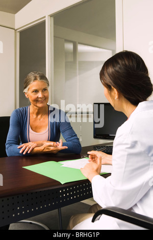 Asian woman doctor in white coat talking on mobile phone at modern ...