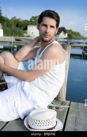 Mediterranean young latin man relaxed on wood pier white hat Stock ...