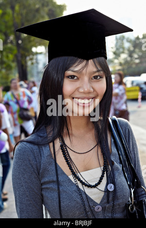 Southeast-Asian university female graduate in graduation gown with ...