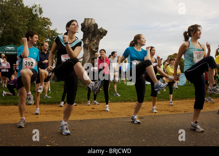 Amateur running club athletes warm-up with group aerobics before a ...