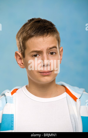 Teenage boy scowling Stock Photo - Alamy