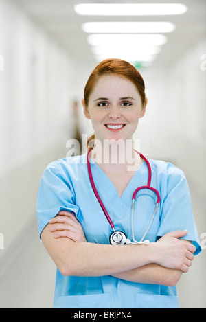 Smiling young adult female nurse holding clipboard with medical consent ...