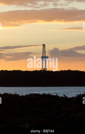 The sun sets behind Wytch Farm oil field in Poole Harbour. Dorset, UK ...