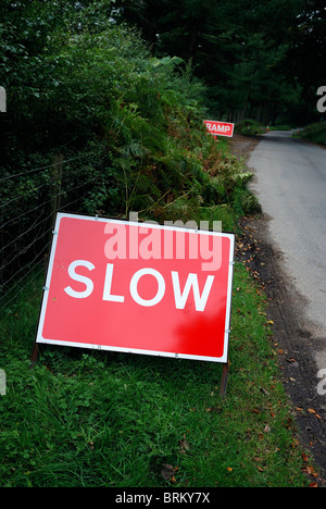 Red SLOW sign on a country 'A road' in Cornwall (focus on Slow). For ...