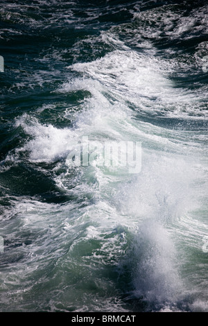 Spray from a wave breaking on the sandy beach in the Seychelles Stock ...