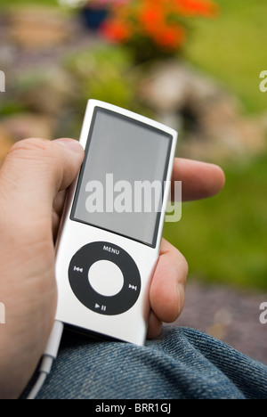 Listening to an Ipod in the garden Stock Photo - Alamy